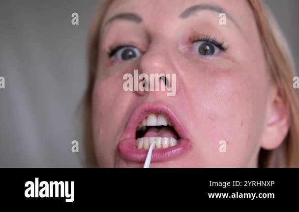 close-up of womans mouth teeth and wooden toothpick. hygiene of the ...