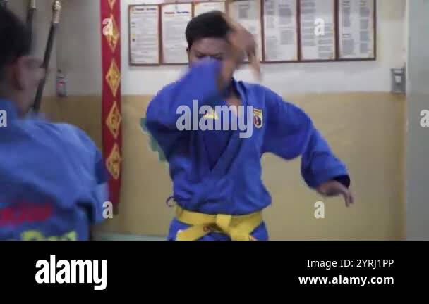 two traditional Vietnamese Martial Art Vovinam artists practice stick ...