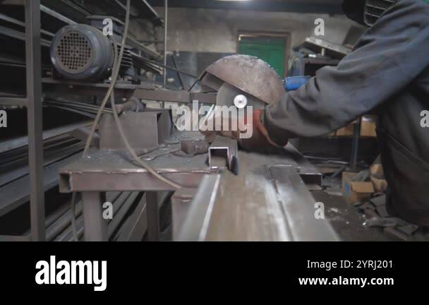Worker in safety protection wear use saw cutting machine to cut metal ...