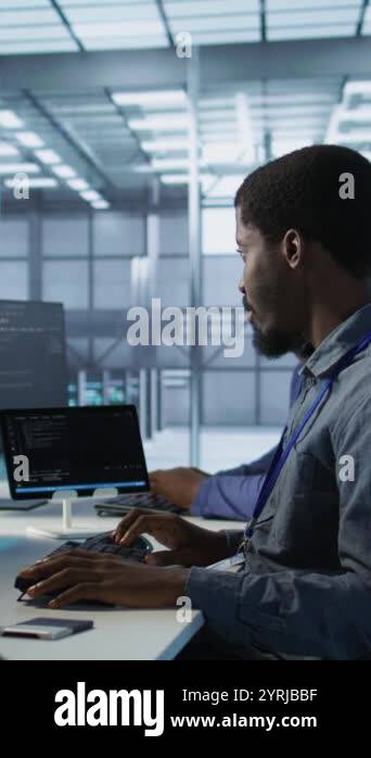 Vertical video Cheerful coworkers in data center implementing AI predictive maintenance systems ...