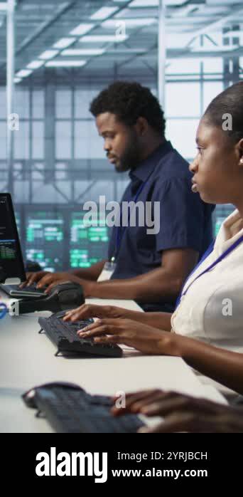 Vertical video IT staff members seeing critical error popup on PC screen in data center ...