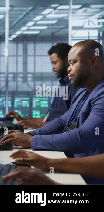 Vertical video Surprised data center technician celebrating after successfully managing to ...