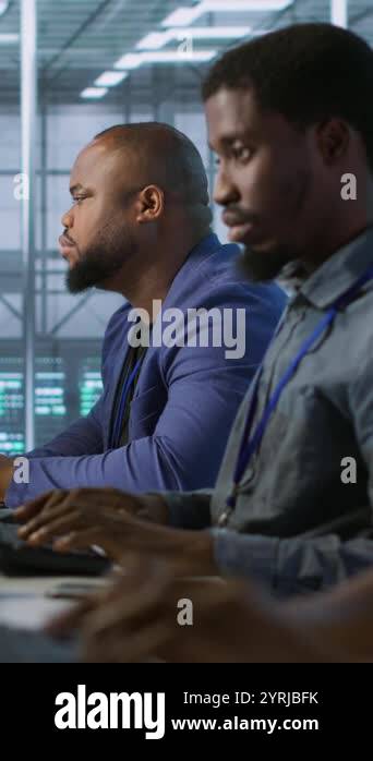 Vertical video Cheerful server room workers laughing together in office ...
