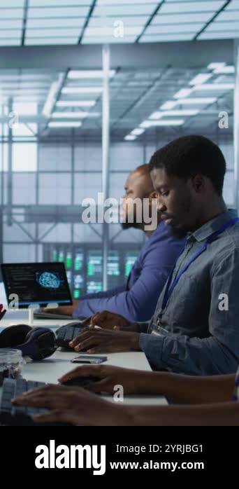 Vertical video Computer scientists in data center implementing AI predictive maintenance systems ...