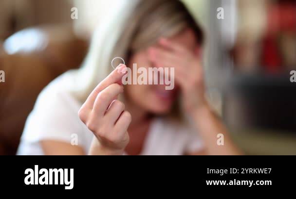 Distraught blonde woman makes facepalm gesture holding wedding ring ...