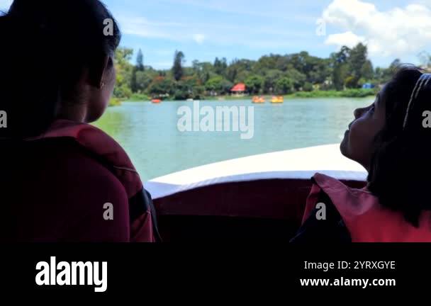 Mother and daughter enjoy a peaceful boat ride, gazing at the scenic ...