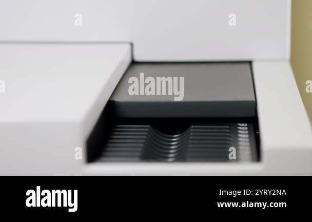 A scientist wearing white gloves loads samples into a scanner for ...