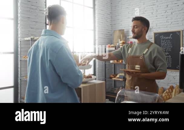 Baker serving pastries to customer in indoor bakery with modern ...