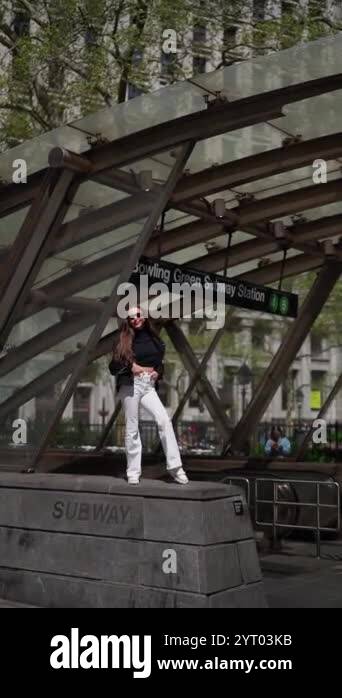 A stylish person poses confidently at a busy NYC subway entrance ...