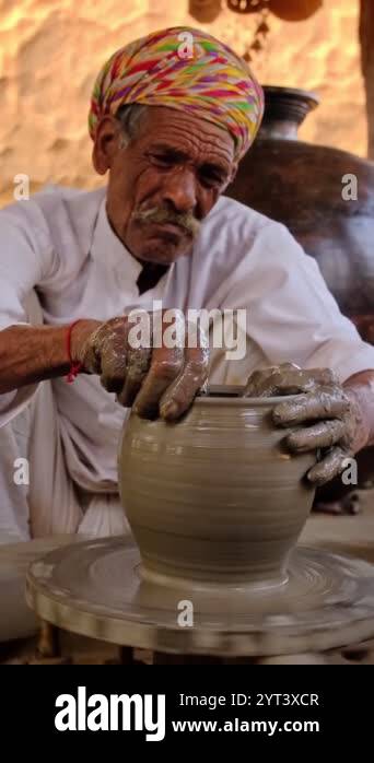 Indian potter at work: throwing the potters wheel and shaping ceramic ...