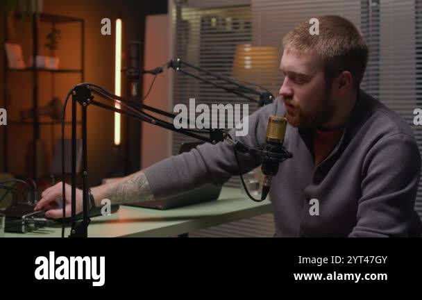 Medium close up shot of young Caucasian man testing sound quality of ...