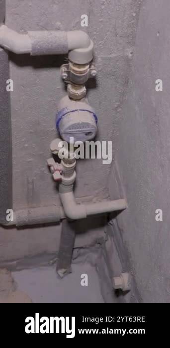Vertical video. A water meter within a plumbing setting. The dusty ...