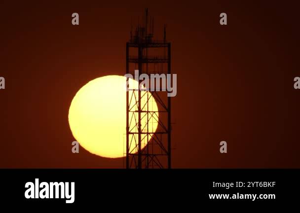 Bright sunset sun behind silhouette of American city downtown ...