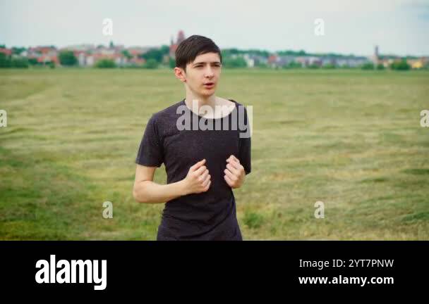 Teenage guy jogging in place, warming up muscles and training endurance ...