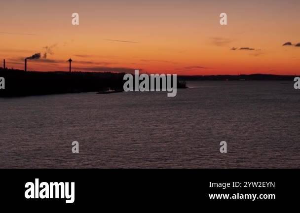 Sideways flight to the right over a lake with dark forested shore and ...