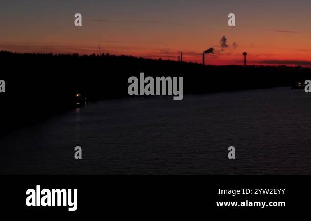 Sideways flight to the left over a lake with dark forested shore and ...