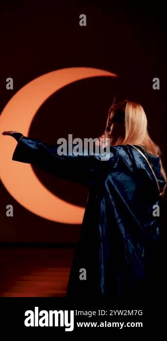 A red-haired sorceress poses with a magic wand against the background ...