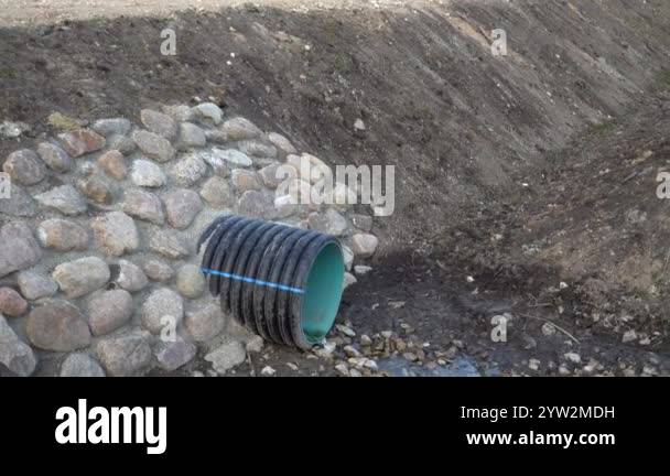 A newly constructed gravel road with a well-engineered embankment and a ...