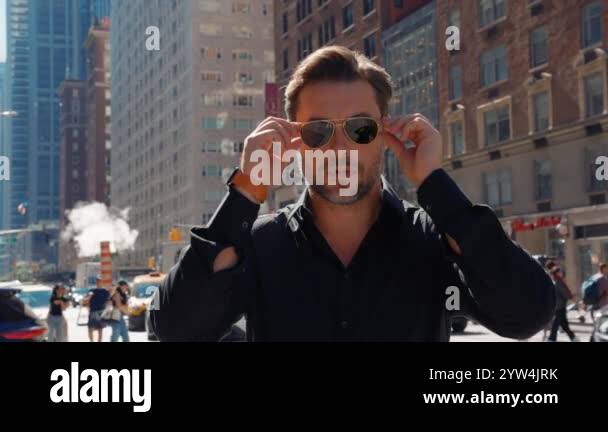 stylish confident man stares into the camera on the streets of new york ...