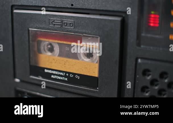 A close-up view of a cassette inside a vintage boombox. The tape and ...