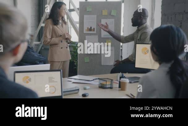 Businesswoman presenting successful project speaking to team clapping ...
