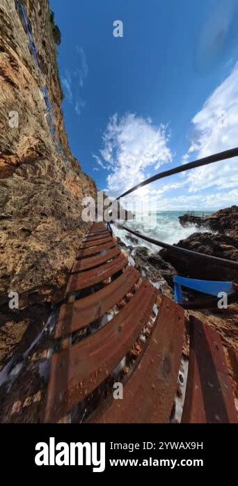 Vertical video. A dynamic slow-motion shot of waves splashing onto a ...