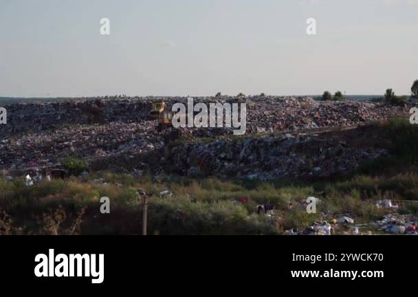 A massive landfill stretches across the landscape, revealing layers of ...