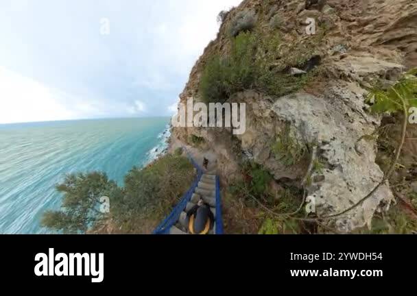A dynamic shot looking down the blue staircase winding along the cliff ...