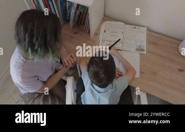 Mom supports her son with his homework, creating a loving environment for learning and growth ...