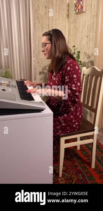 A beautiful young woman in a stylish dress and glasses plays the ...