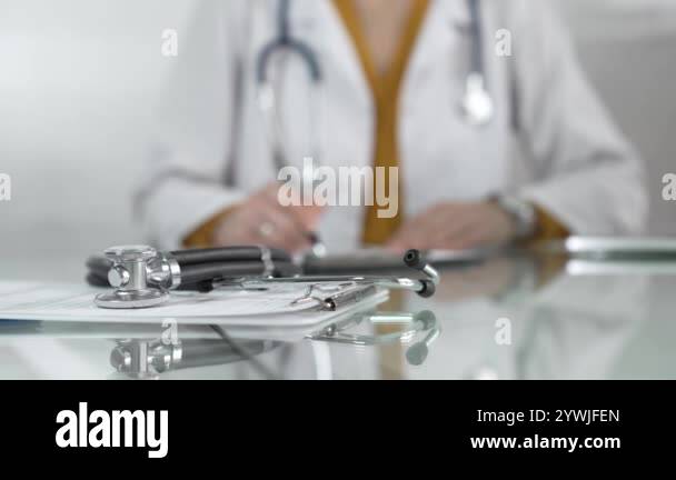 Stethoscope and medication history records form are on a glass table ...
