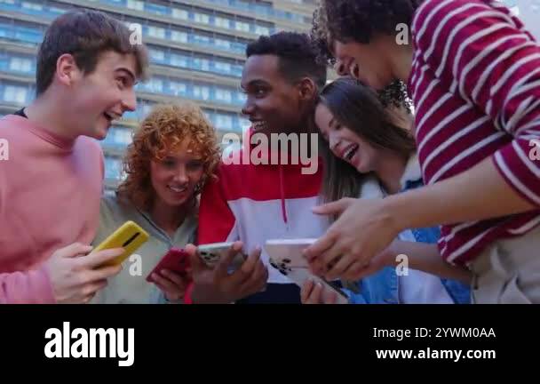 Young group of multiracial students using mobile phones together at ...