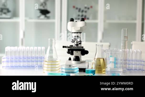 A modern lab setup with a sophisticated microscope and various glassware for research and ...