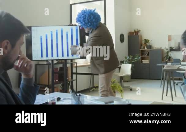 Zoom out shot of Caucasian man and Black woman whispering and laughing ...