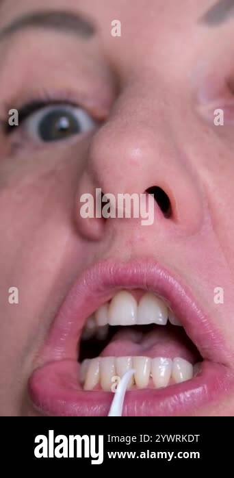 close-up of womans mouth teeth and wooden toothpick. hygiene of the ...