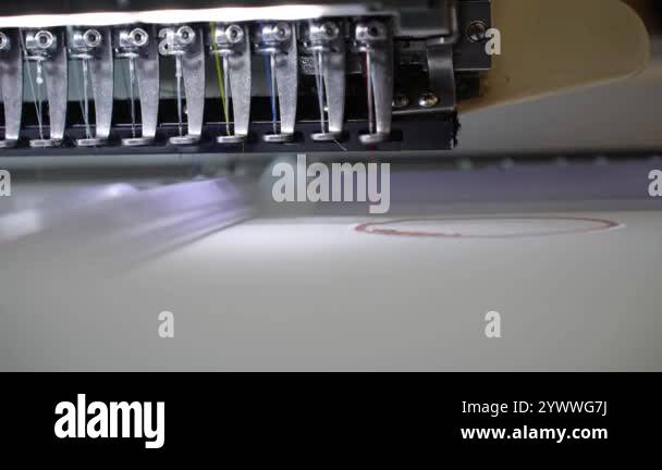 Embroidery machine in the process of embroidering company logo on ...