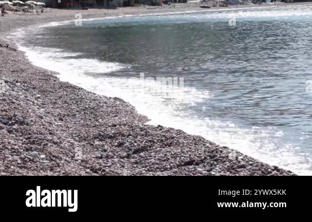 Sea coast, sandy shore with stony pebble beach where people relax. Wind ...