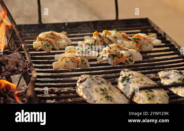 Chef prepares a delicious seafood meal of fish and shellfish on a hot ...