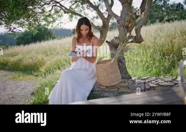 Girl author making notes at copybook sitting under tree alone. Cute ...