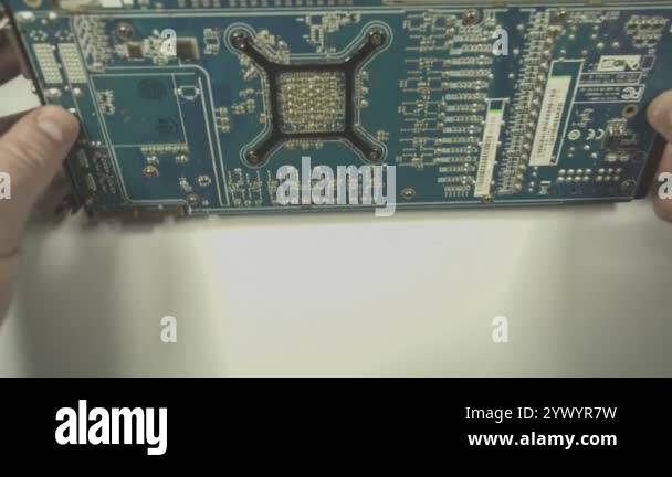 Person handling and examining a computer graphics card, showcasing its ...