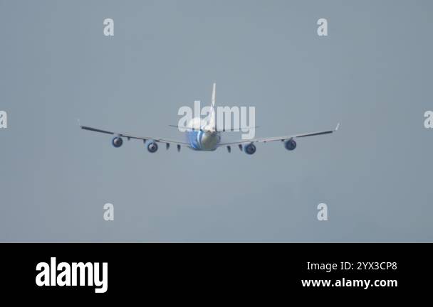 Footage rear view of heavy four-engine cargo aircraft gaining altitude ...