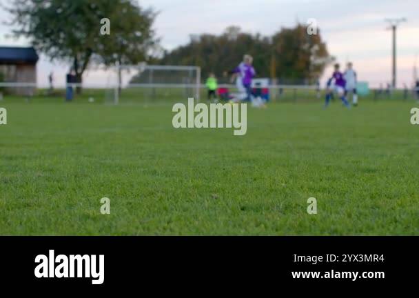 Bokeh effect, players playing football on the field exciting youth soccer game taking place with ...