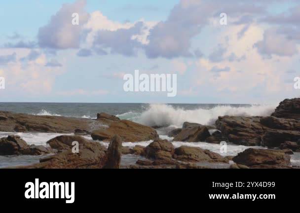 Powerful ocean waves crash against rugged rocks in stunning slow motion ...