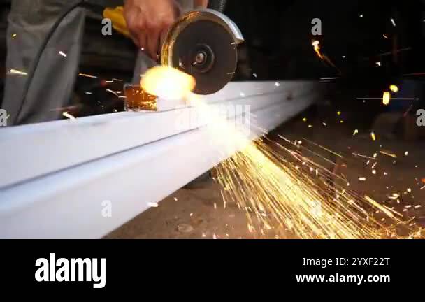 Male hands of young mechanic cuts iron using electric grind wheel at ...