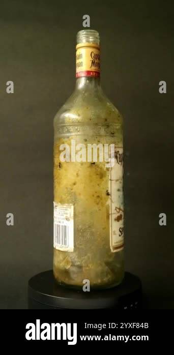 A vintage liquor bottle, aged to perfection, rotates gracefully ...