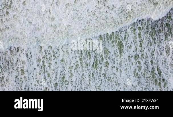 Frothy waves crash forcefully against the shore of Vesterhavet in an ...
