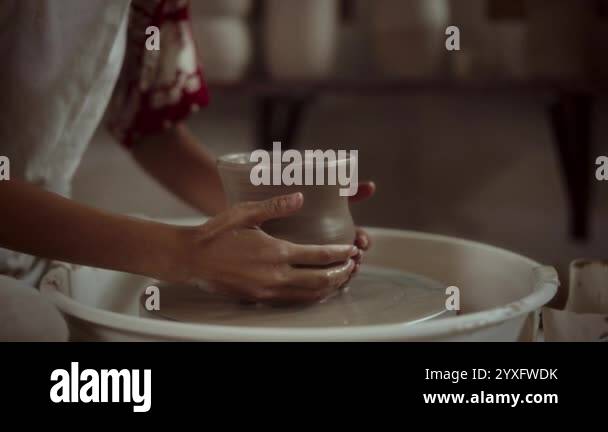 Artisan gently removing finished pottery from the potter's wheel, handling with care and ...