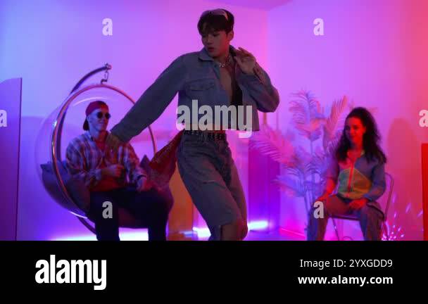 Skilled asian dancer moving to modern music while multicultural friend ...