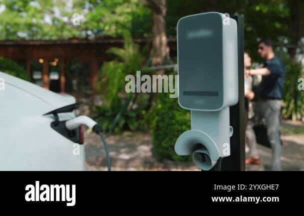 Slow motion couple recharge electric cars battery from charging station ...