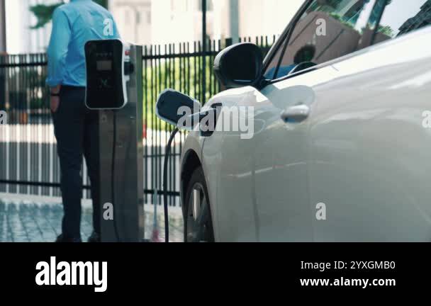 Suit-clad businessman with progressive ambition leaning on his electric ...